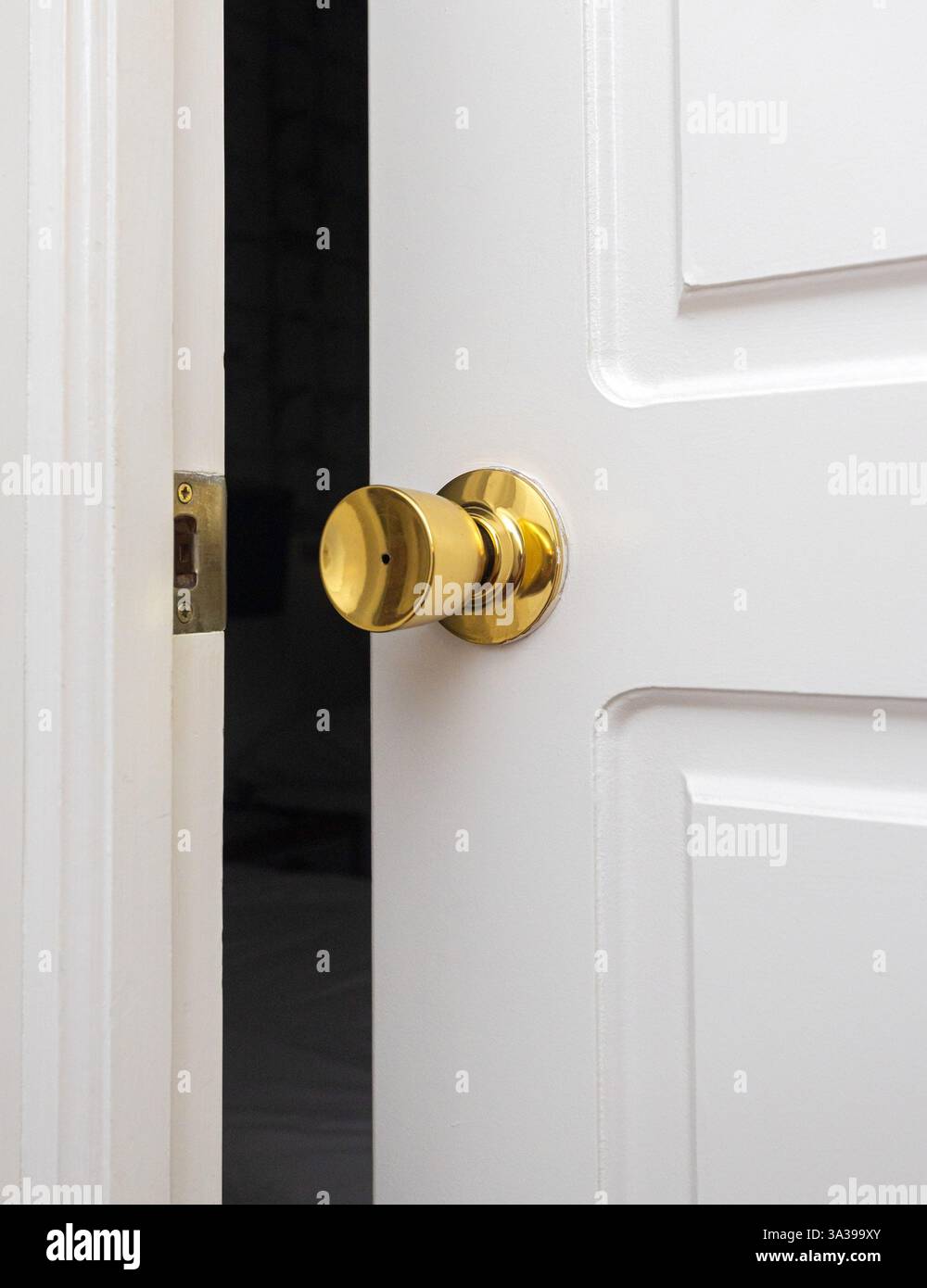 Golden doorknob on white wooden door opening to dark room, concept of ...