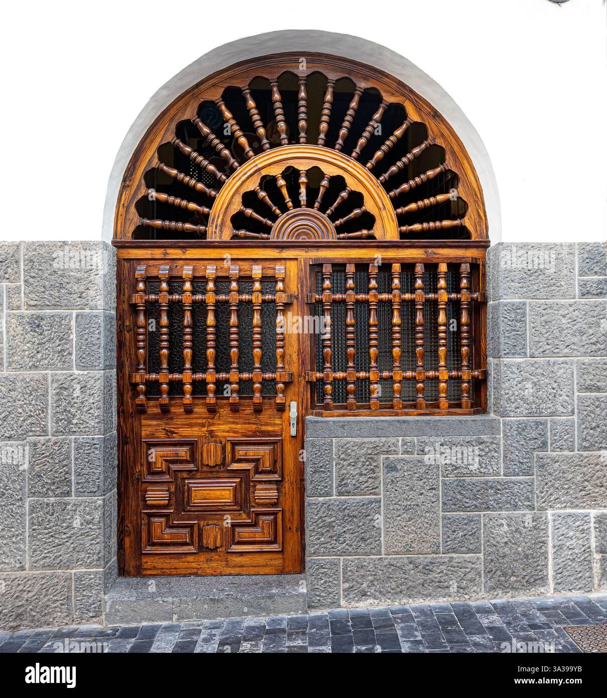 Ornate wooden door featuring a transom window with intricate carvings ...