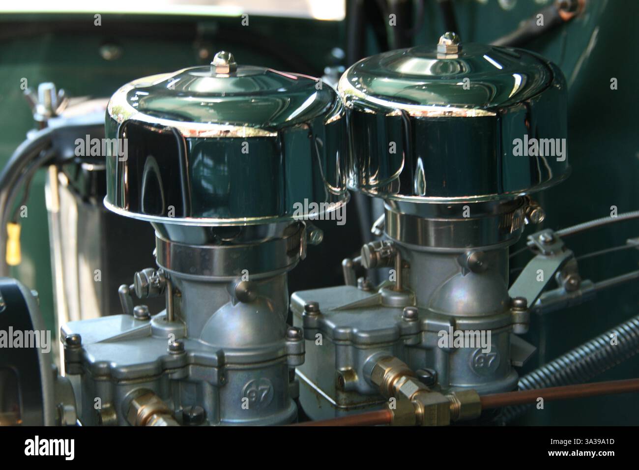 A pair of single barrel carburetors on the engine of a classic car ...