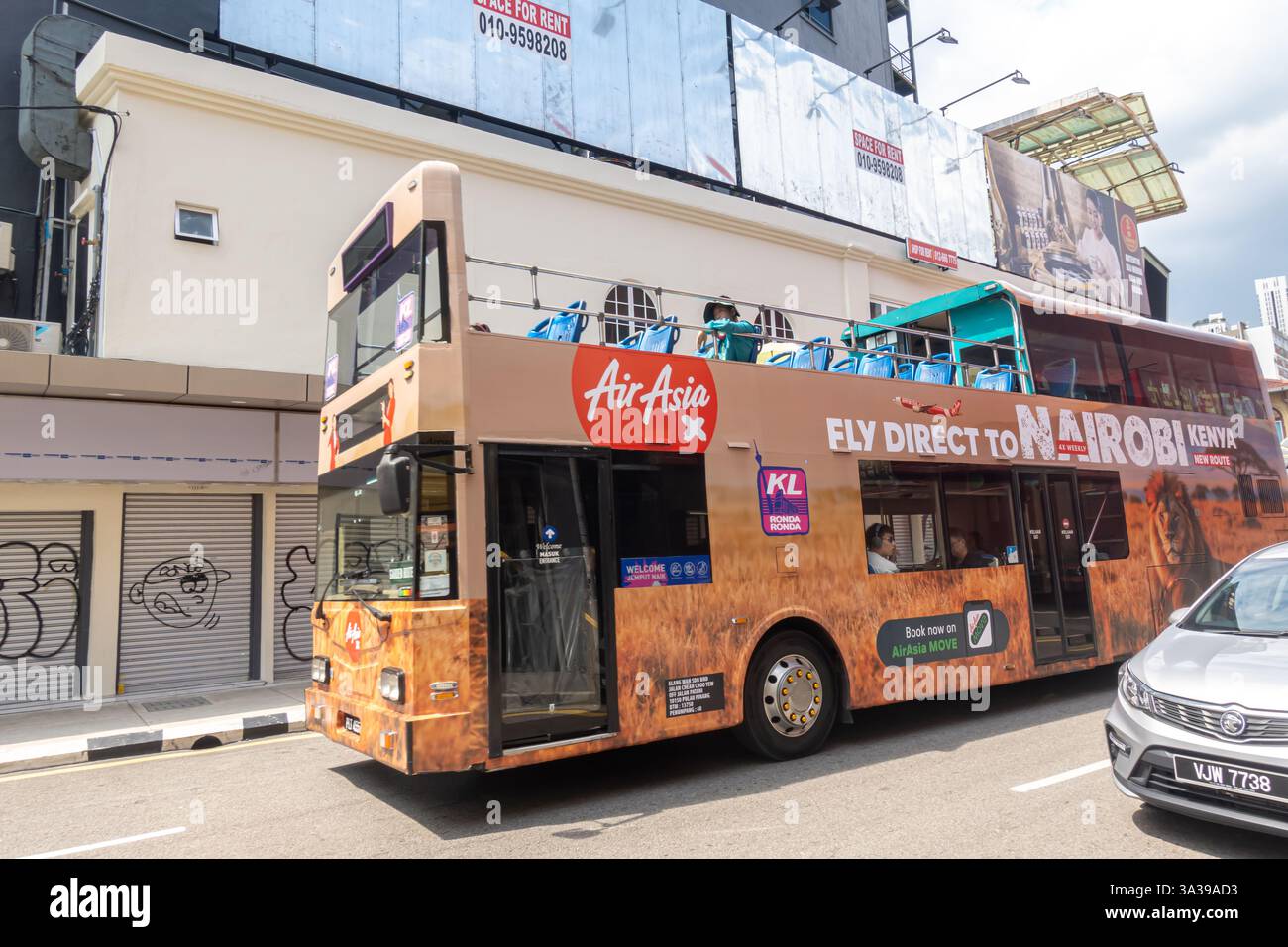 a double-decker bus advertising Air Asia with the text "FLY DIRECT TO ...