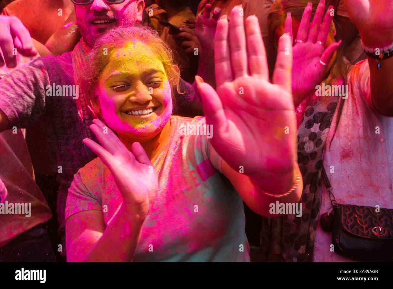 Kolkata, India. 14th Mar, 2025. A woman is seen painted whit colored ...