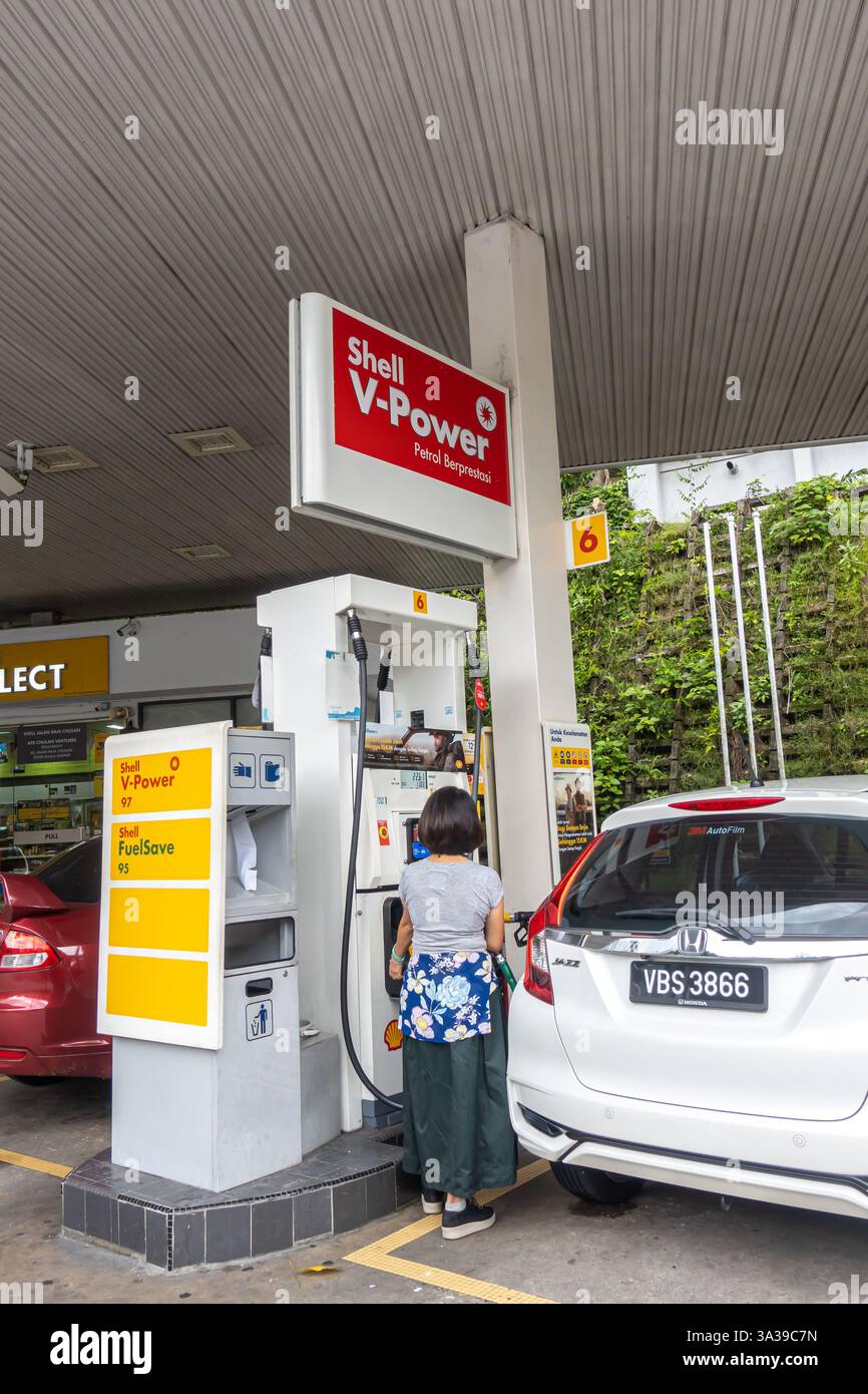 Kuala Lumpur. woman refueling a white Honda Jazz at a Shell gas station ...