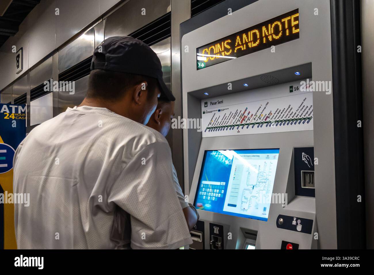 a person using a ticket vending machine at an MRT (Mass Rapid Transit ...