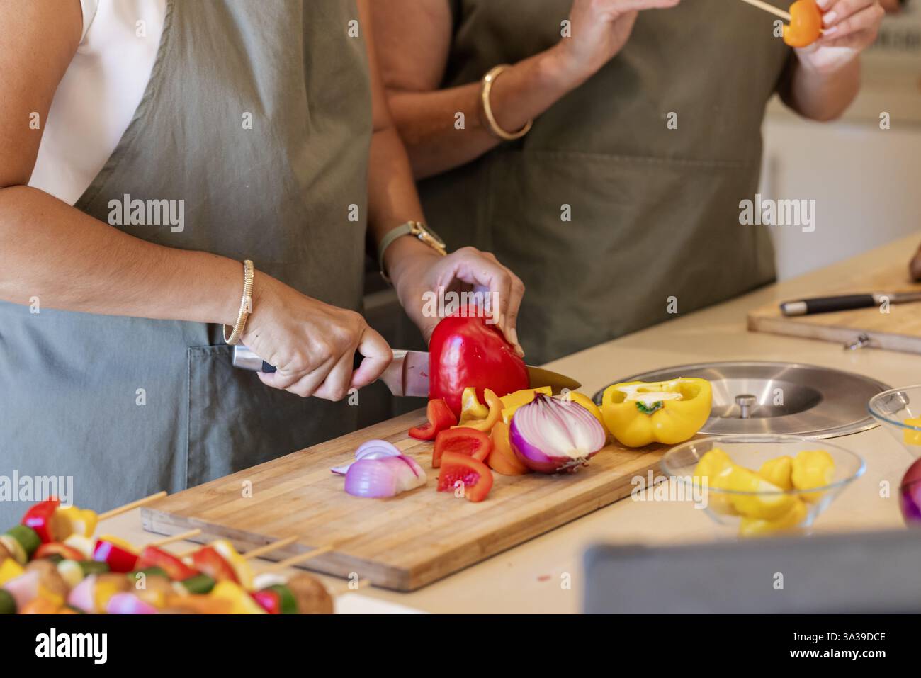 Seniors preparing colorful vegetables together in kitchen, enjoying ...