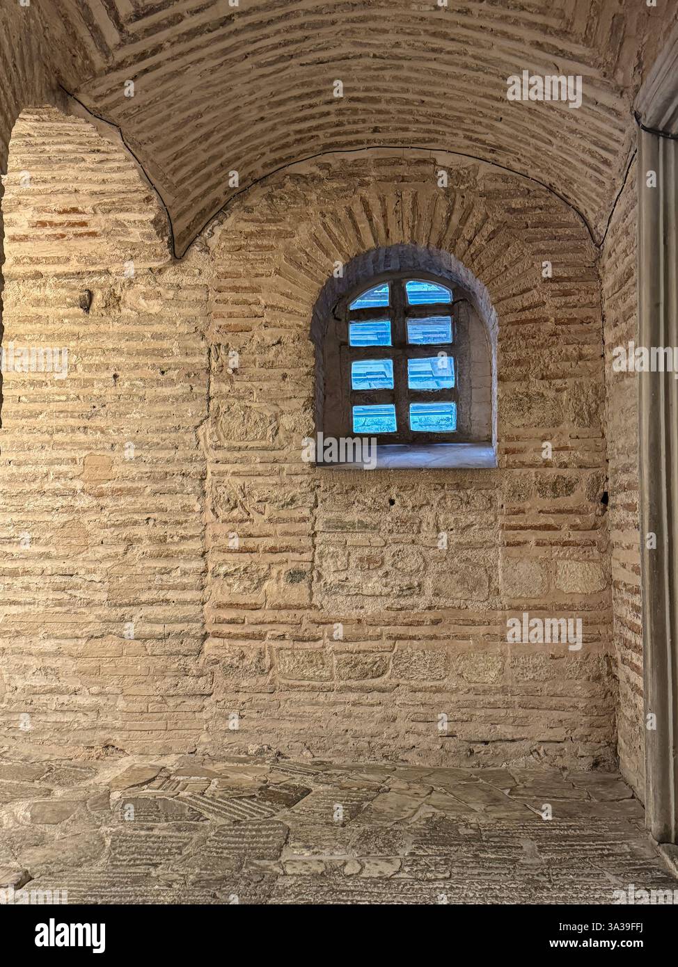 A detailed depiction of a historic arched window set within brickwork ...