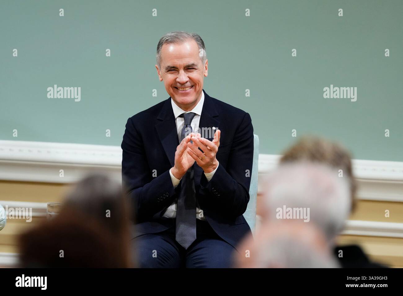 Prime Minister Mark Carney applauds during a swearing in ceremony at ...