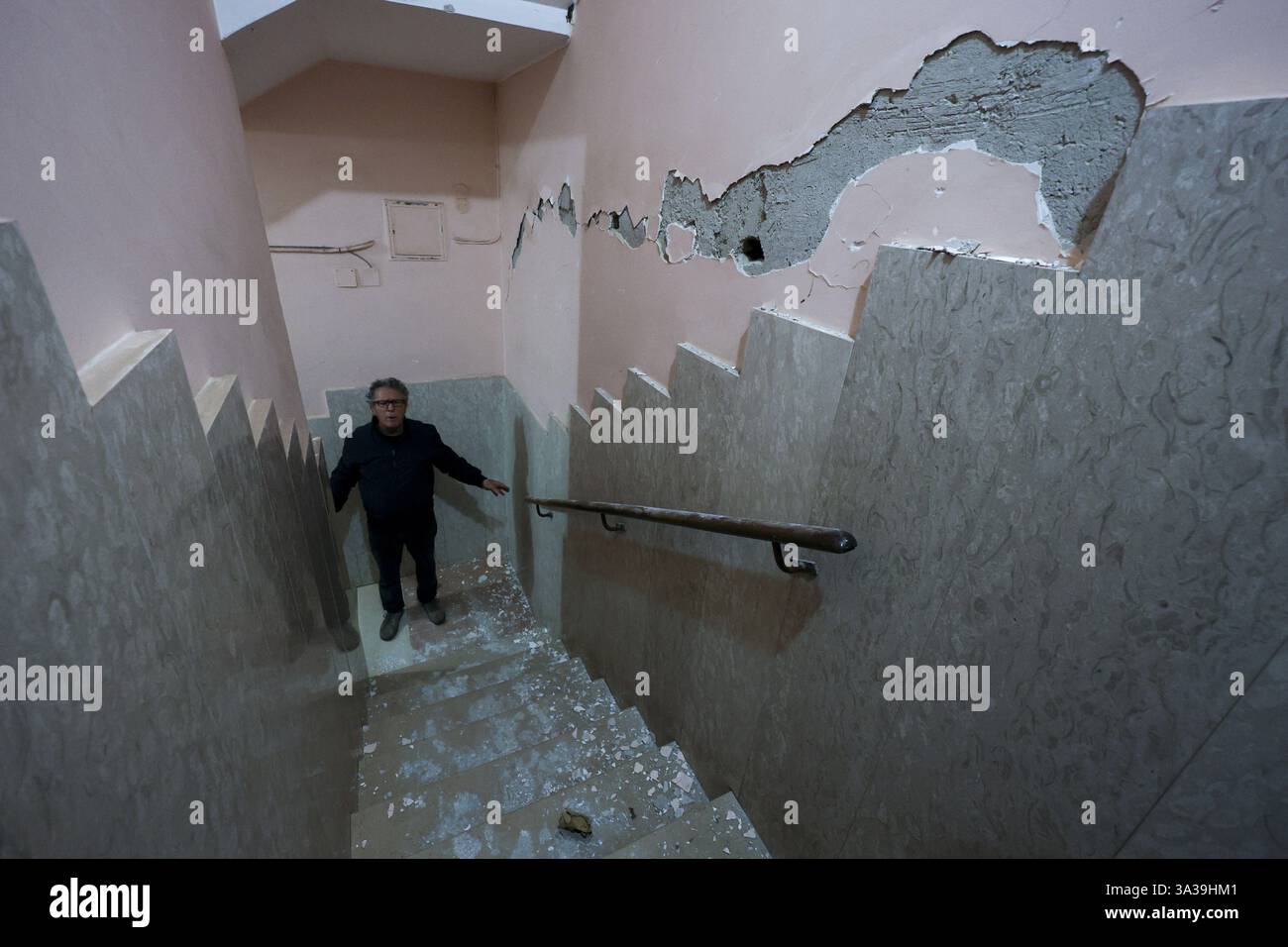 A person points to injuries on the stairs caused after a magnitude 4.4 ...