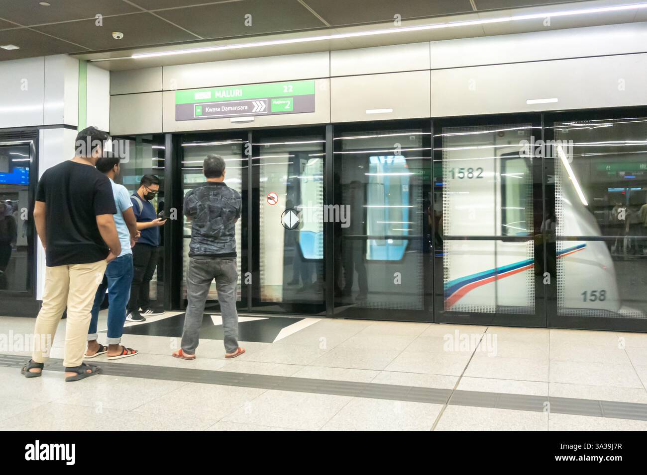 Train arriving to the platform screen doors of the MRT Sungai Buloh ...