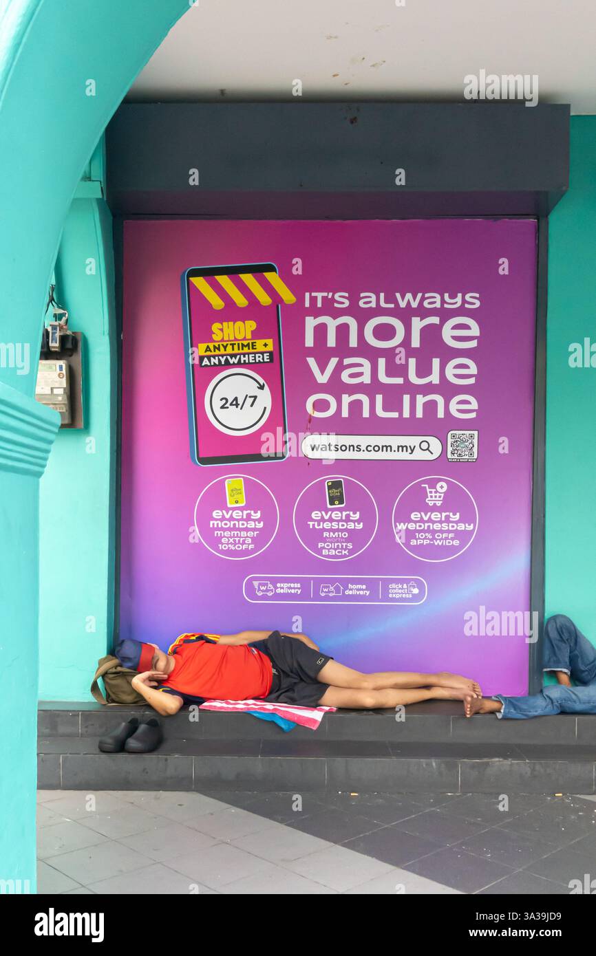 Homeless man sleeping on the ground, a promotional display for Watsons ...