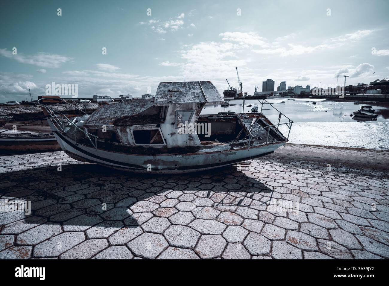 A decayed, abandoned fishing boat with a rusted, broken hull and ...