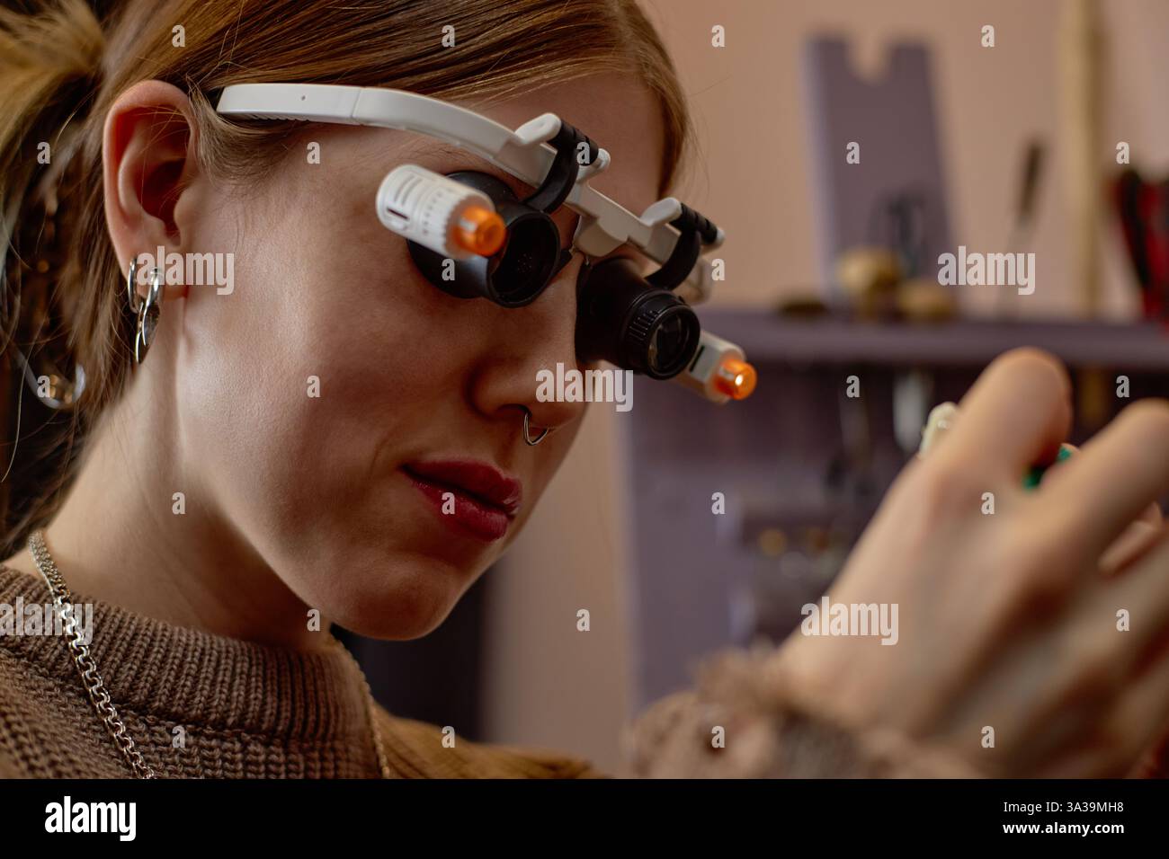 Focused individual wearing advanced magnifying glasses, concentrating on delicate work. Setting ...