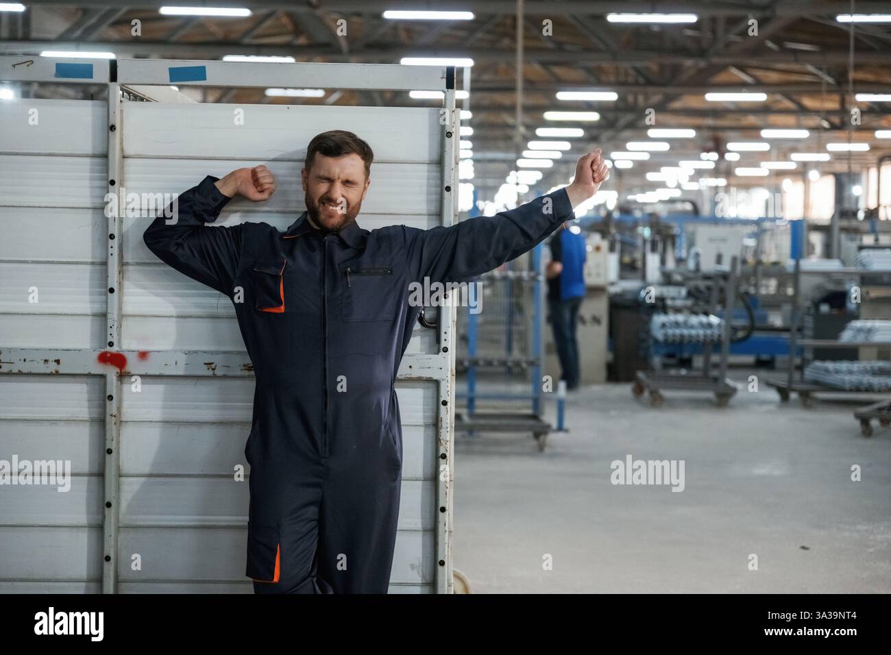 Feeling sleepy, taking a break. Factory worker is indoors Stock Photo ...