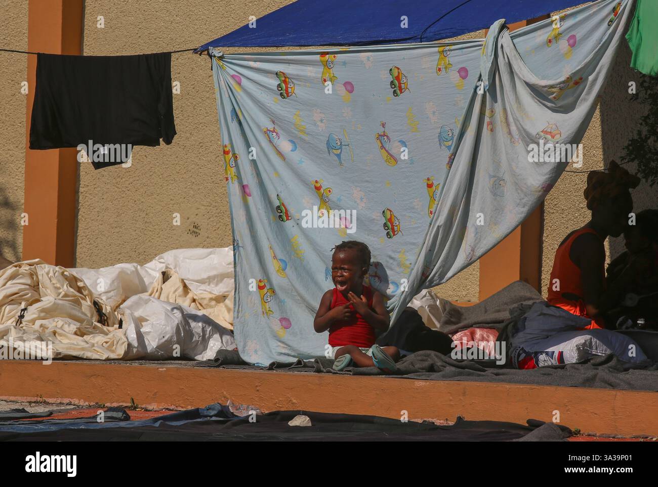 A child cries at a Mormon church converted into a shelter for people ...