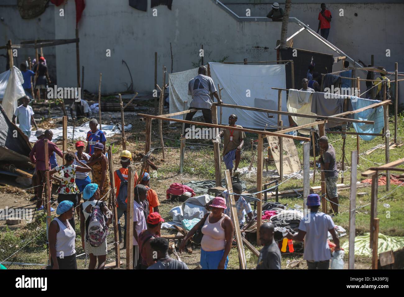 People displaced by gang violence build tents at a Mormon church being ...