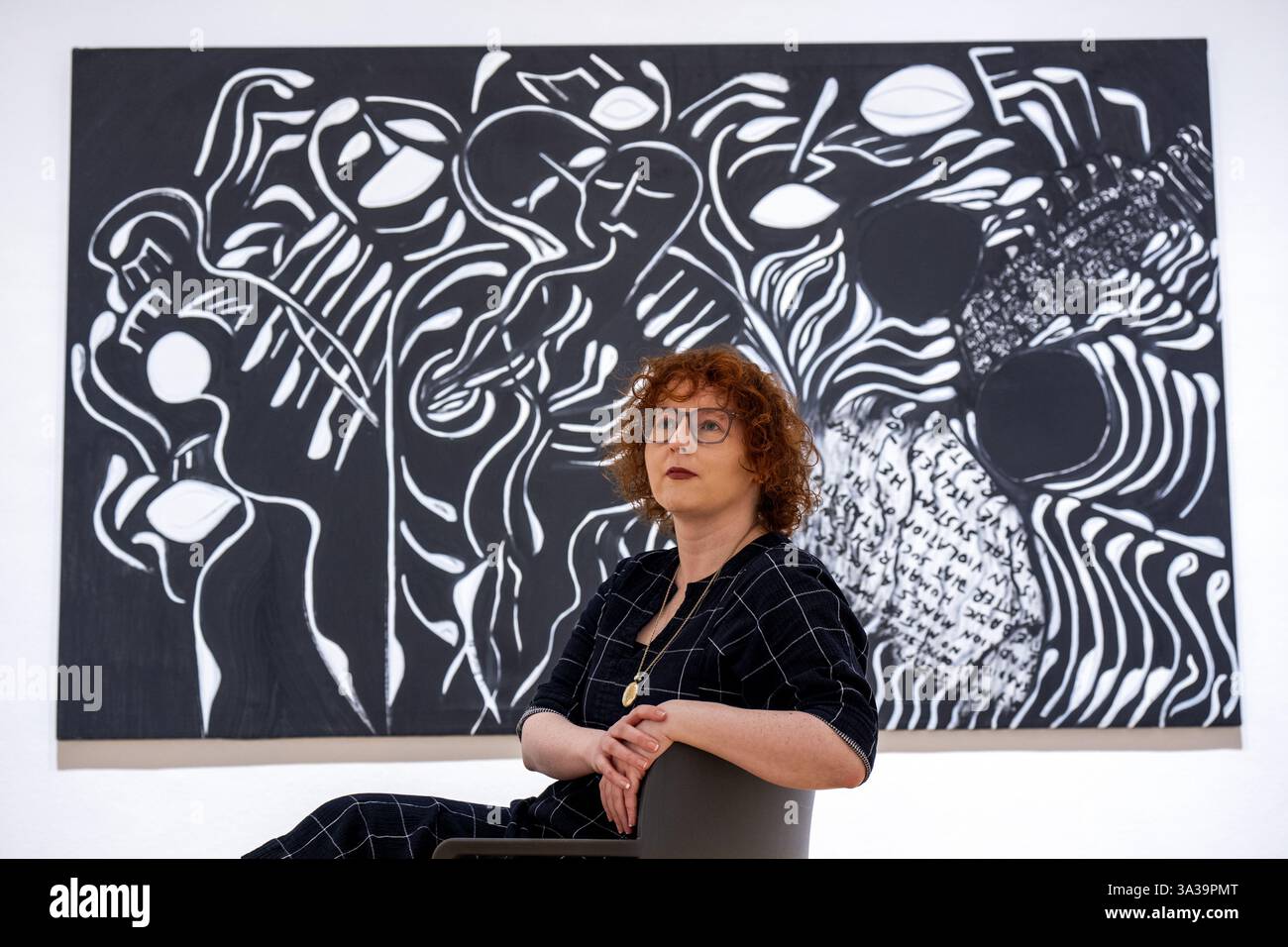 Senior curator Stephanie Straine alongside an acrylic painting titled ...