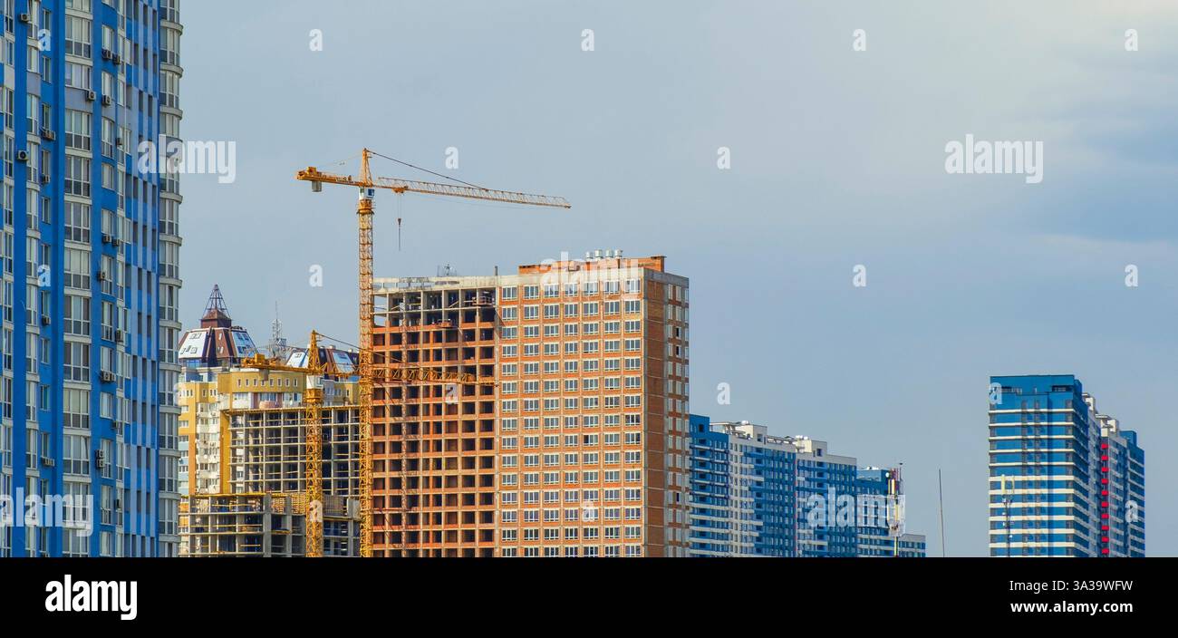 A bustling construction site operates amidst a backdrop of modern ...