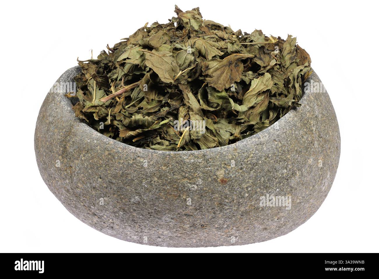 peppermint tea leaves in a natural river stone bowl isolated on white ...