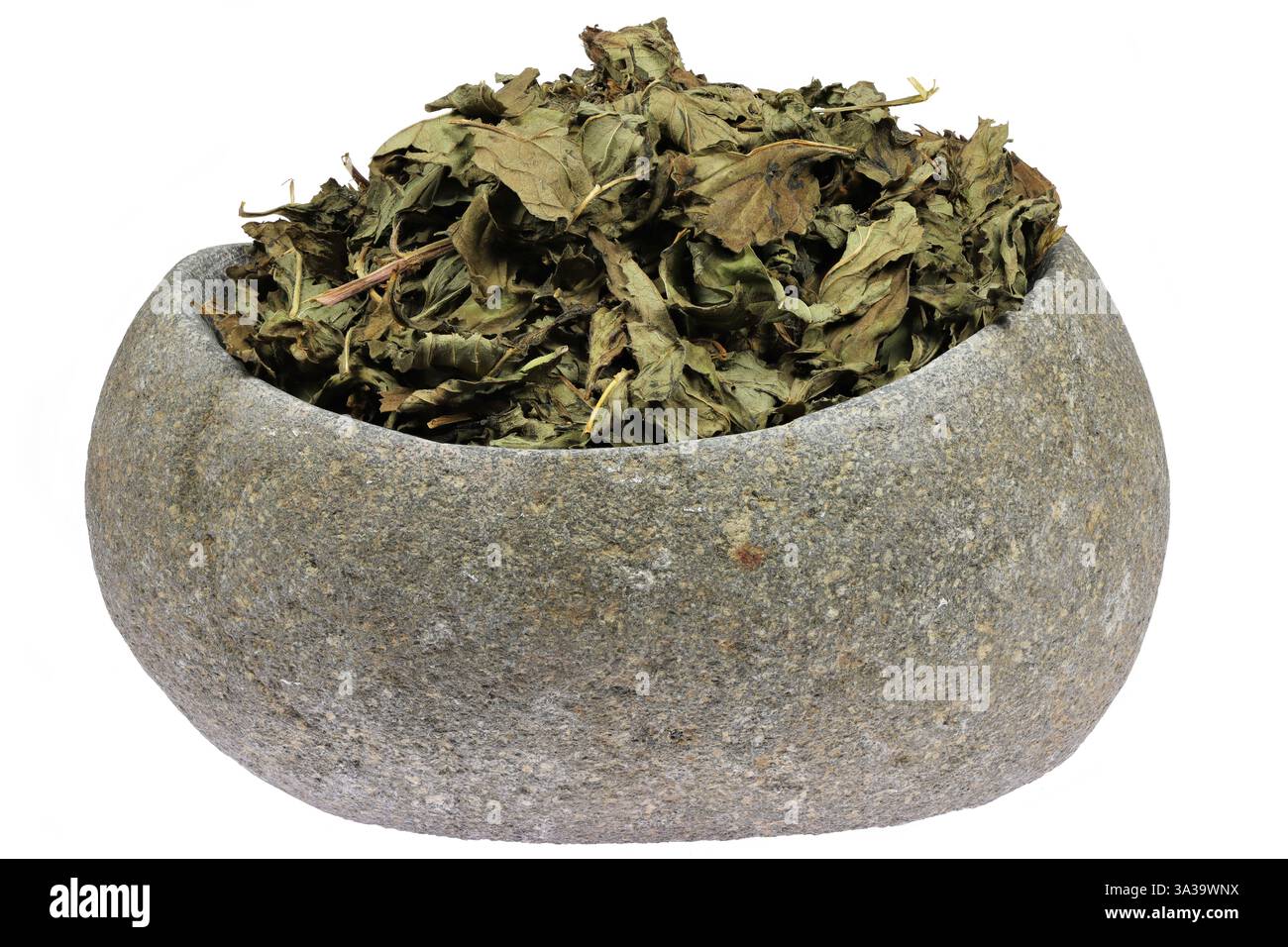 peppermint tea leaves in a natural river stone bowl isolated on white ...