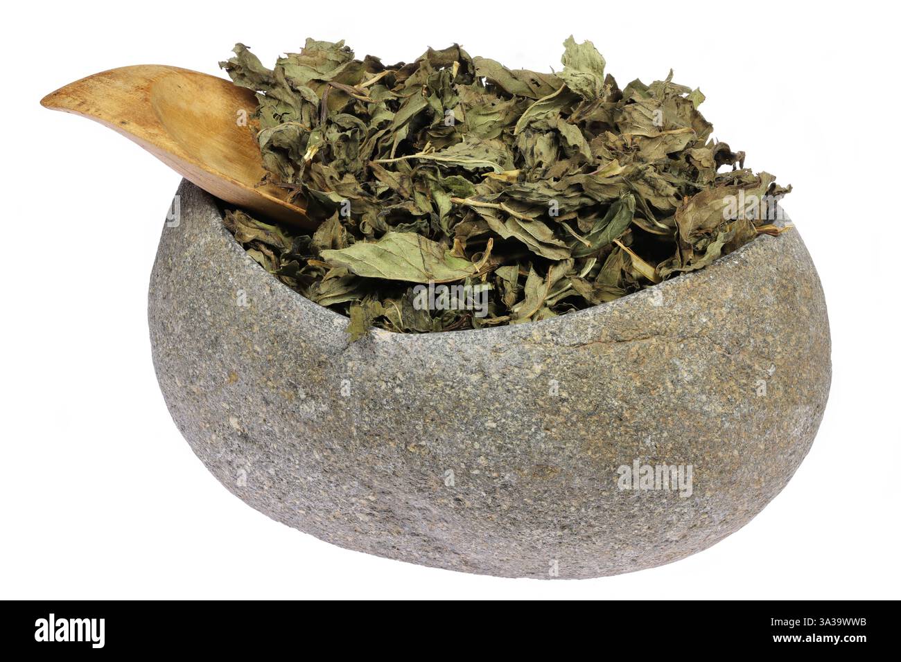 peppermint tea leaves in a natural river stone bowl isolated on white ...