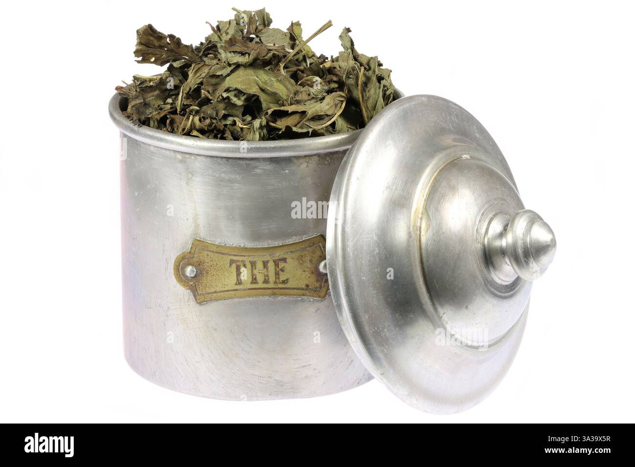 peppermint tea leaves in a vintage French aluminum lidded tin isolated ...