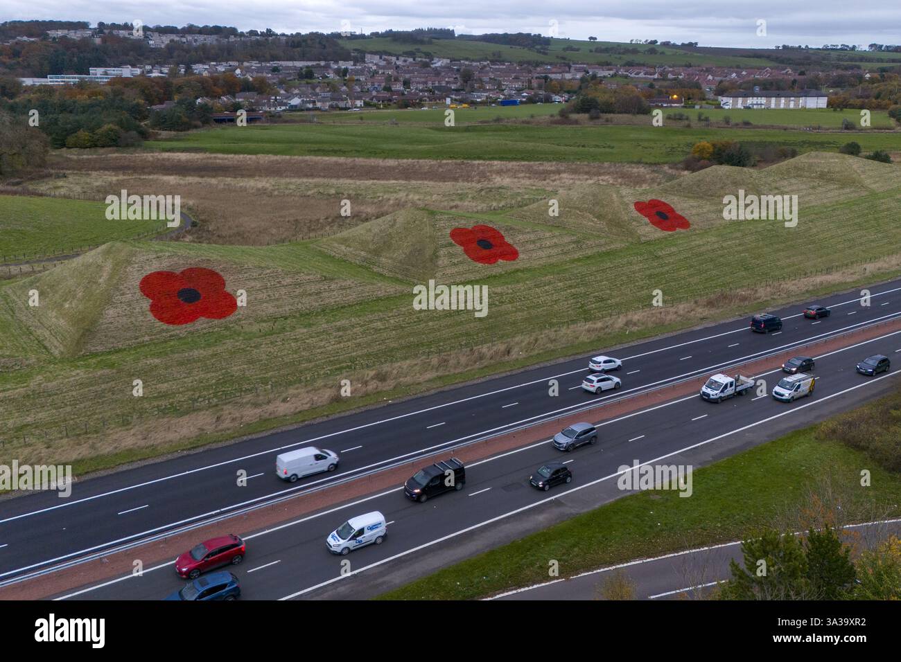 Giant poppies painted onto the grass pyramids alongside the M8 motorway ...