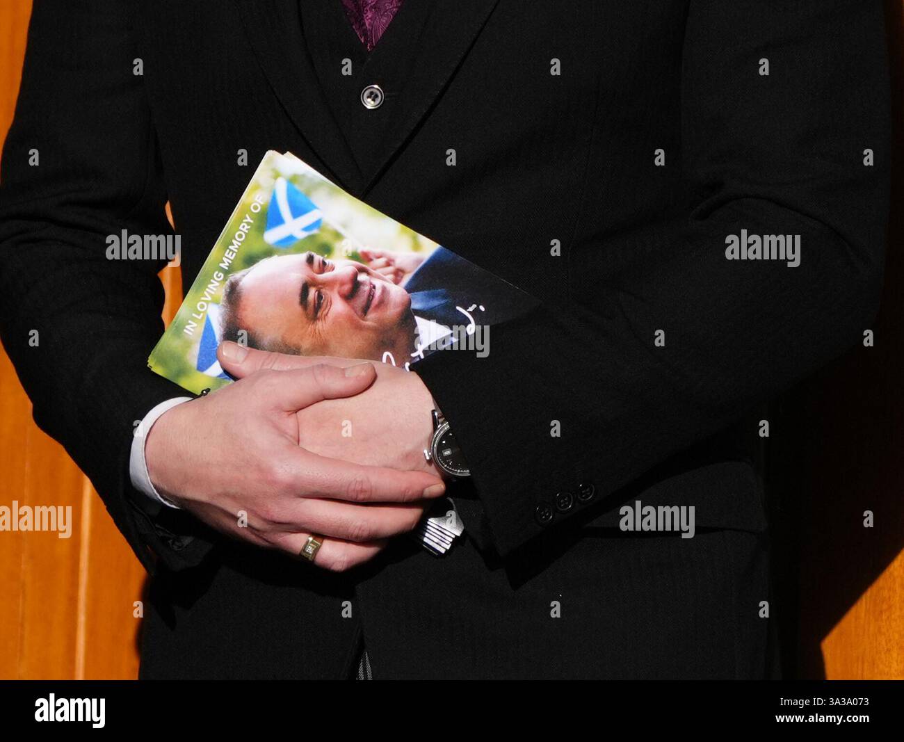 A man holds the order of service at the funeral of former first ...