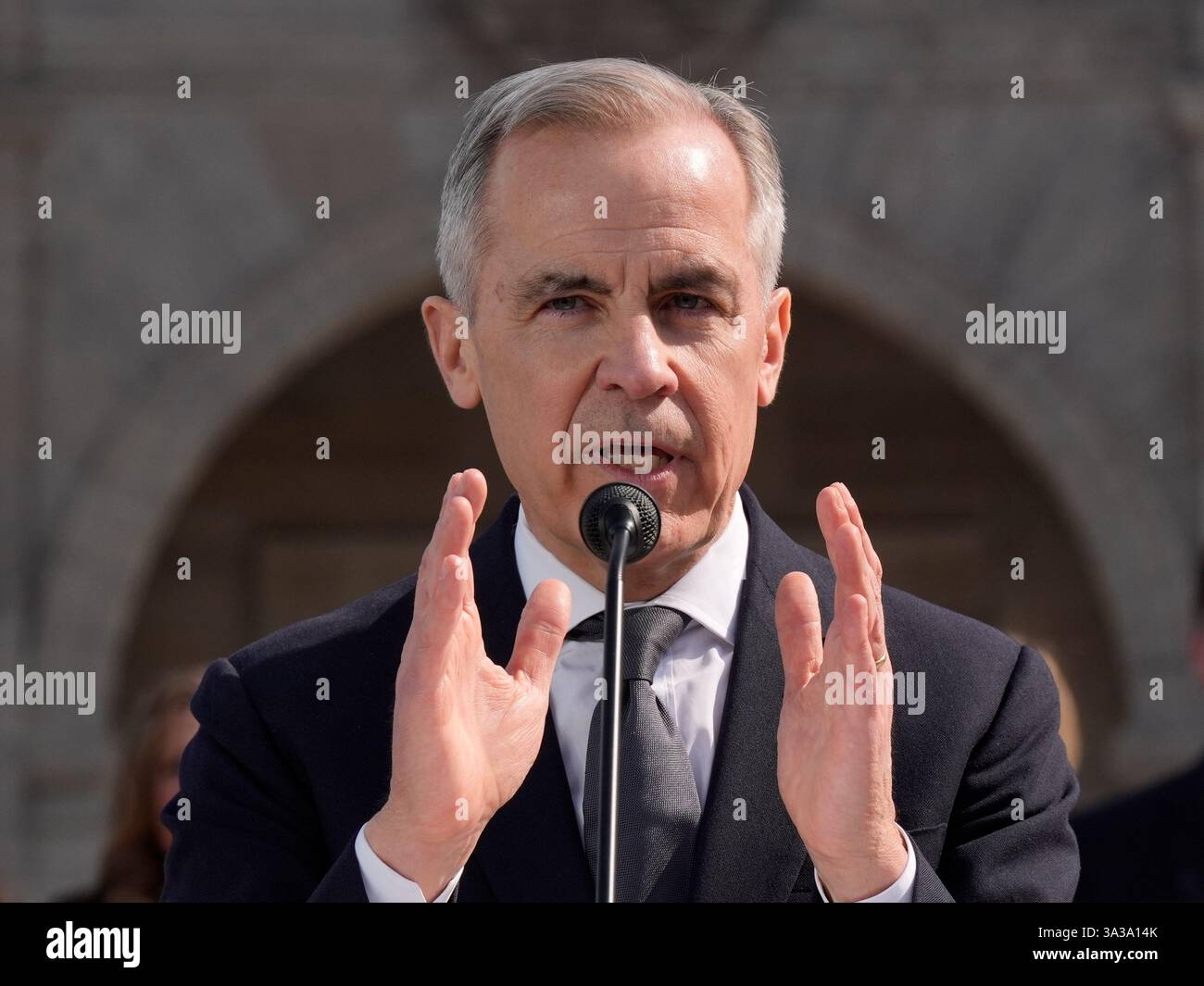 Prime Minister Mark Carney holds a press conference as members of his ...