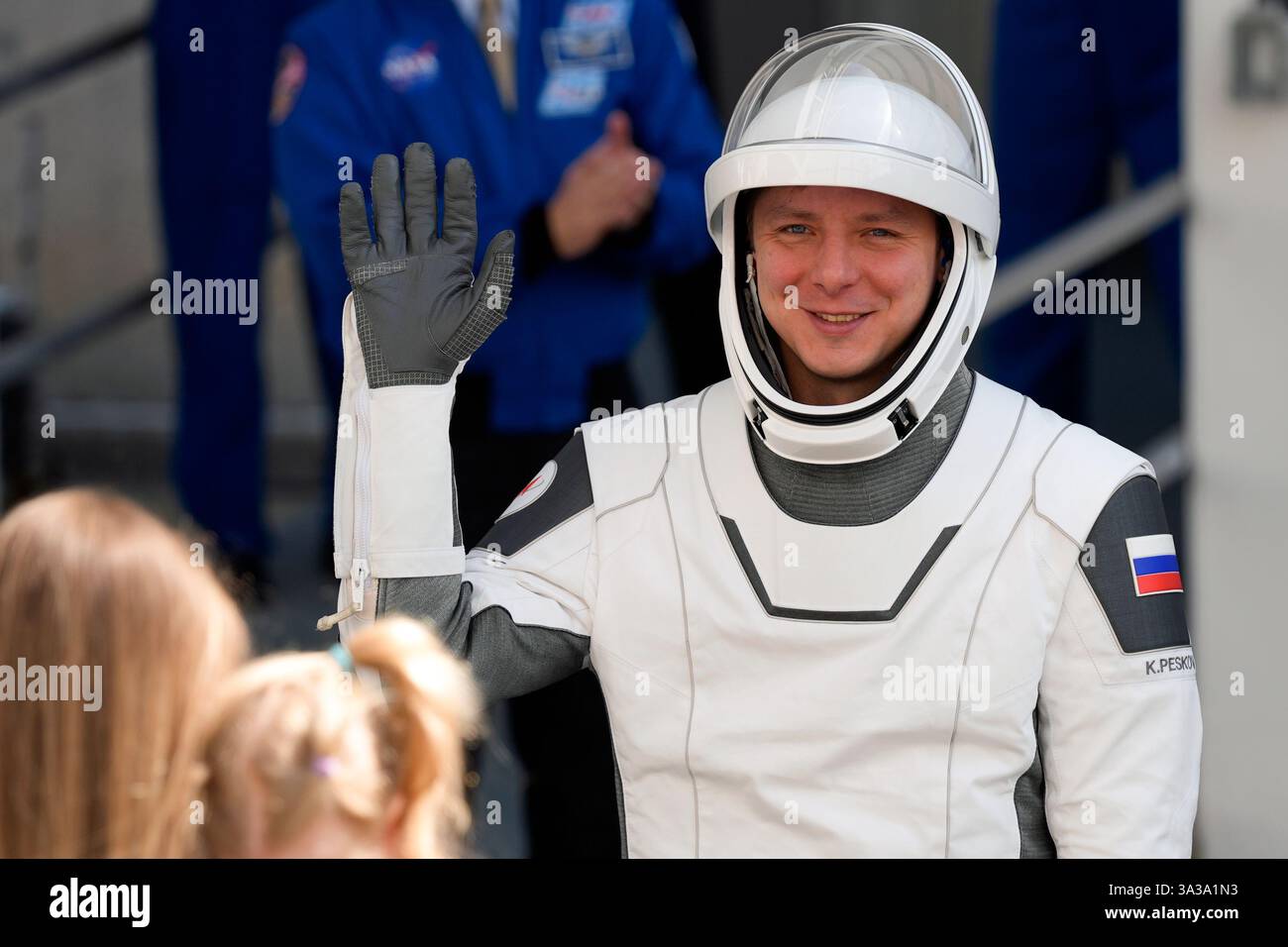 Cosmonaut Kirill Peskov waves as he leaves the Operations and Checkout ...