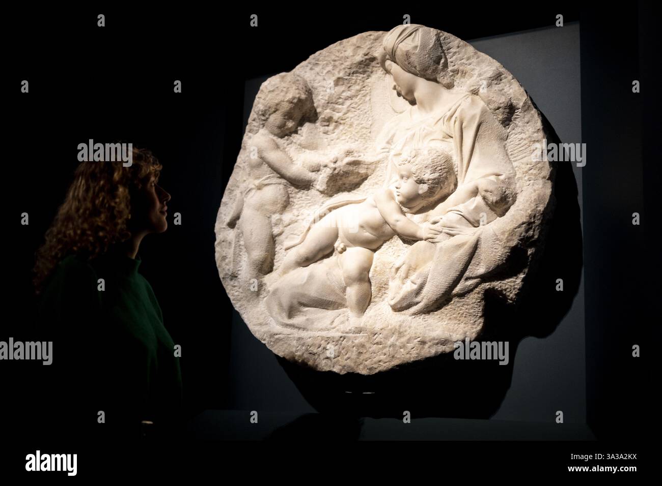 A gallery assistant with The Virgin and Child with the Infant St John ...