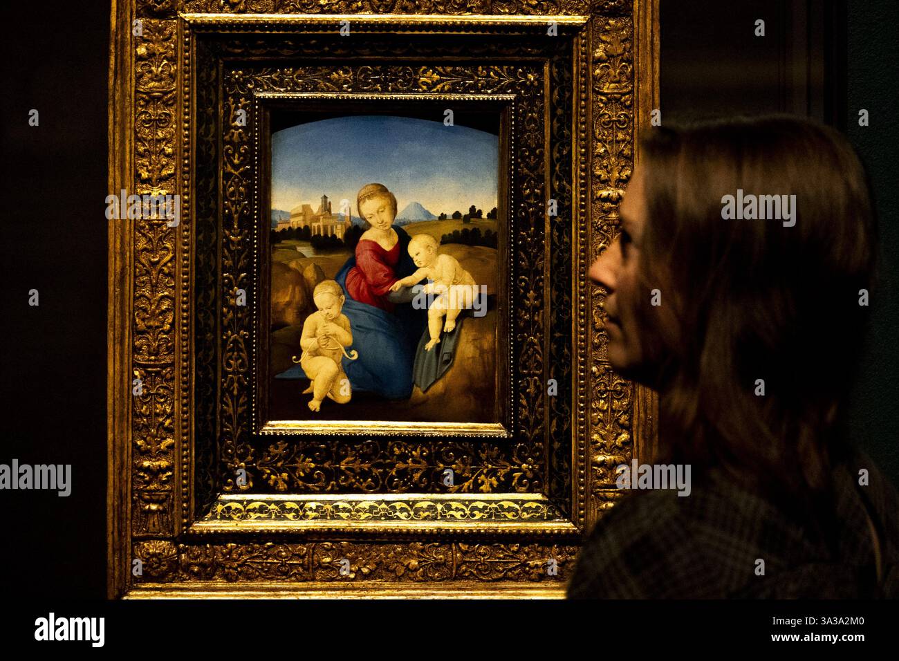 A gallery assistant with The Virgin and Child with the Infant St John ...