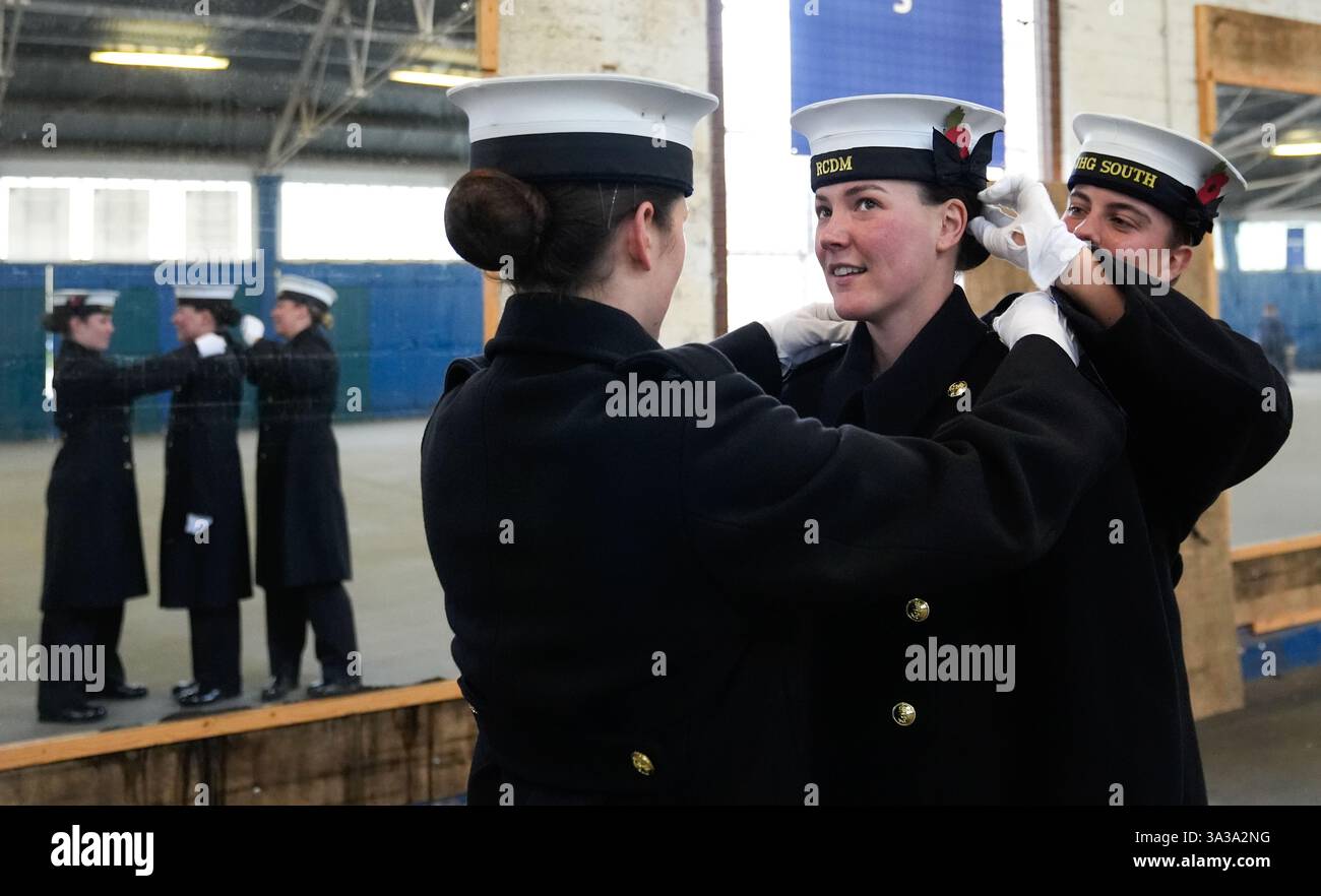 A Royal Navy rating has their uniform adjusted by colleagues before ...