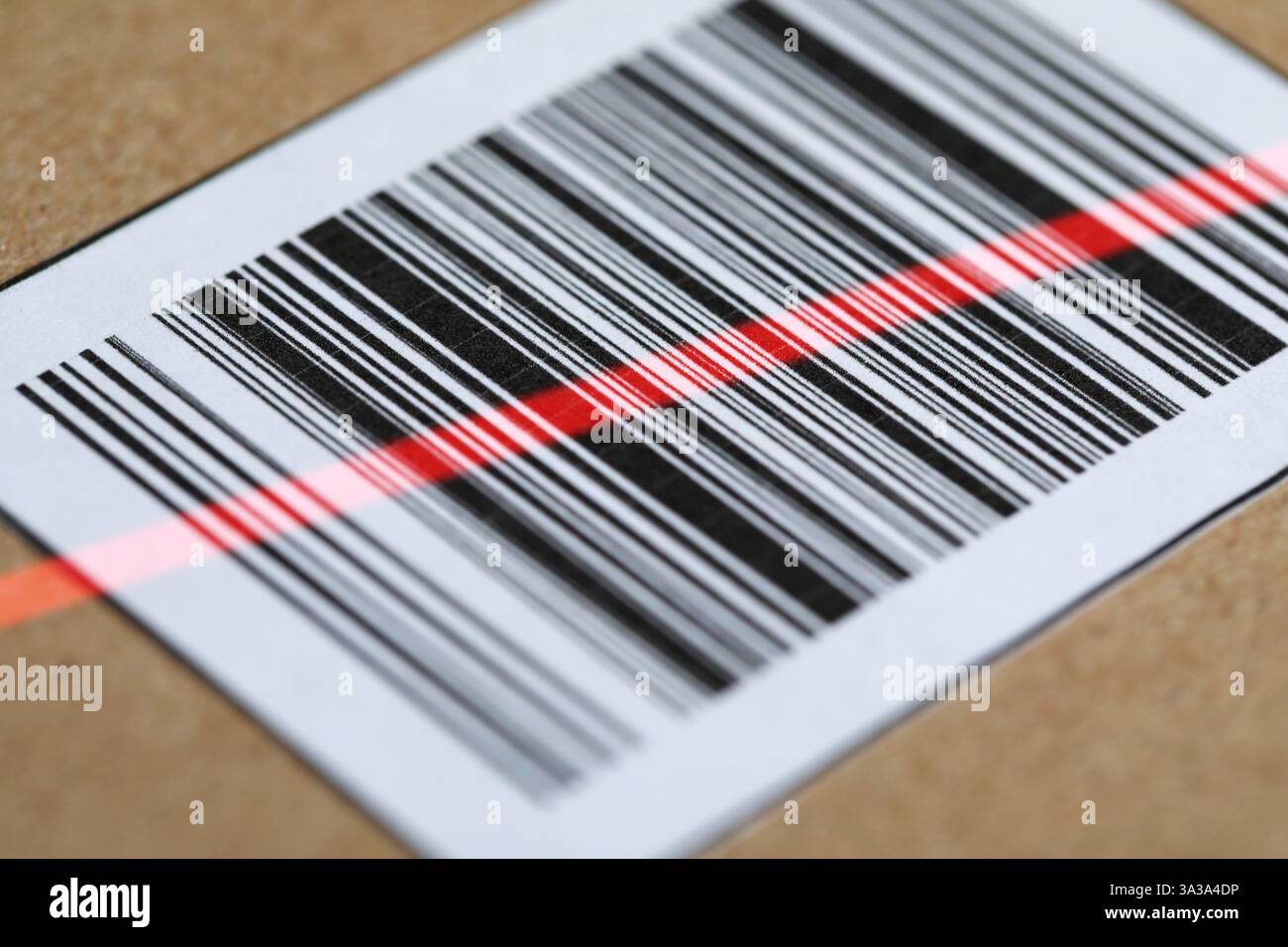 Parcel with label, closeup. Red laser light on barcode for scanning ...