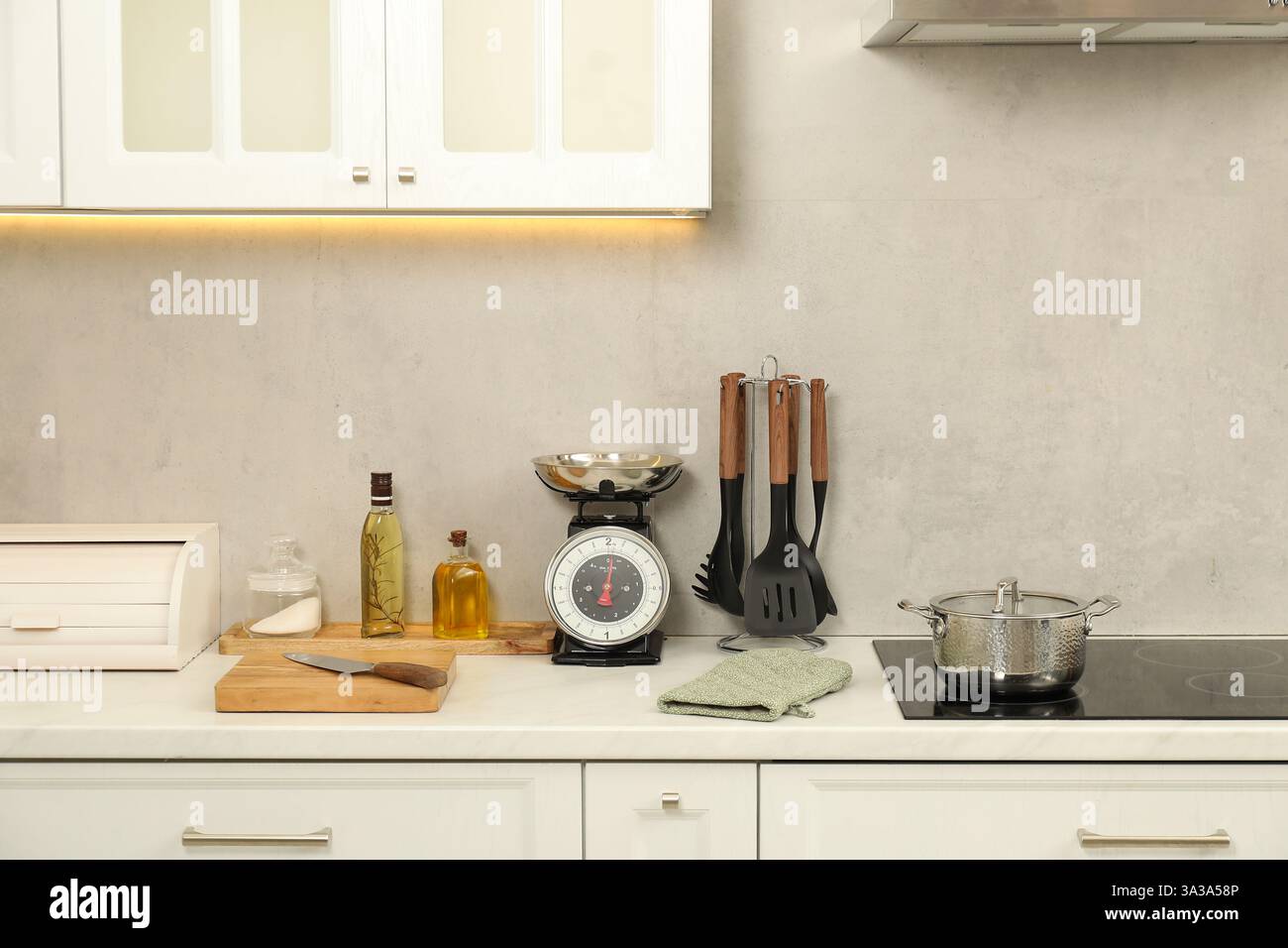 Retro mechanical kitchen scale and other utensils on white marble ...