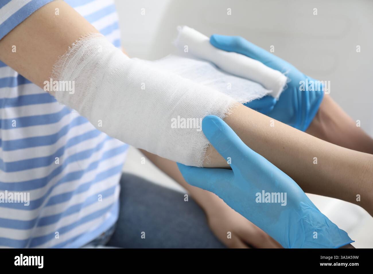 Doctor bandaging patient's elbow in clinic, closeup Stock Photo - Alamy