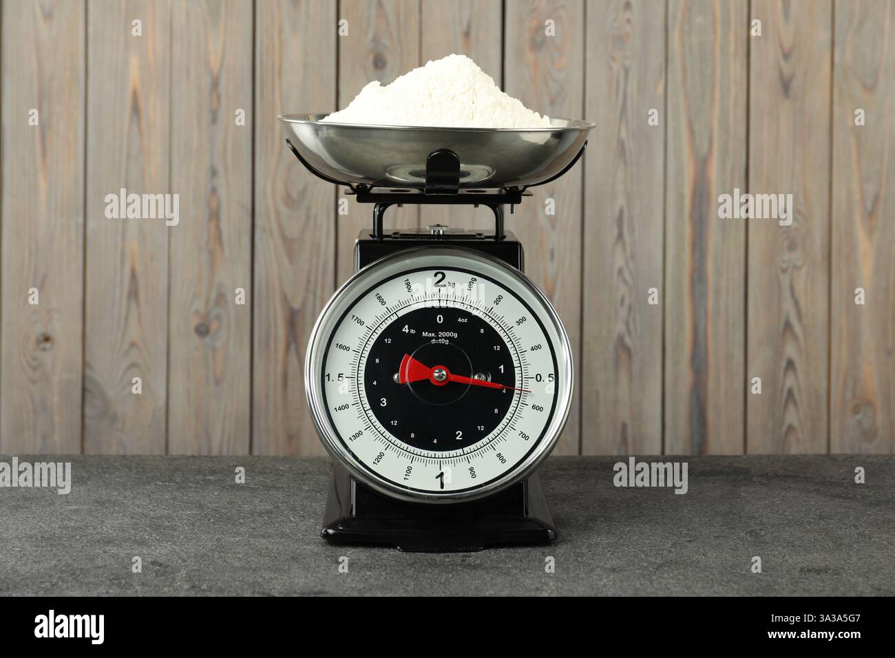 Retro mechanical kitchen scale with flour on grey table Stock Photo - Alamy