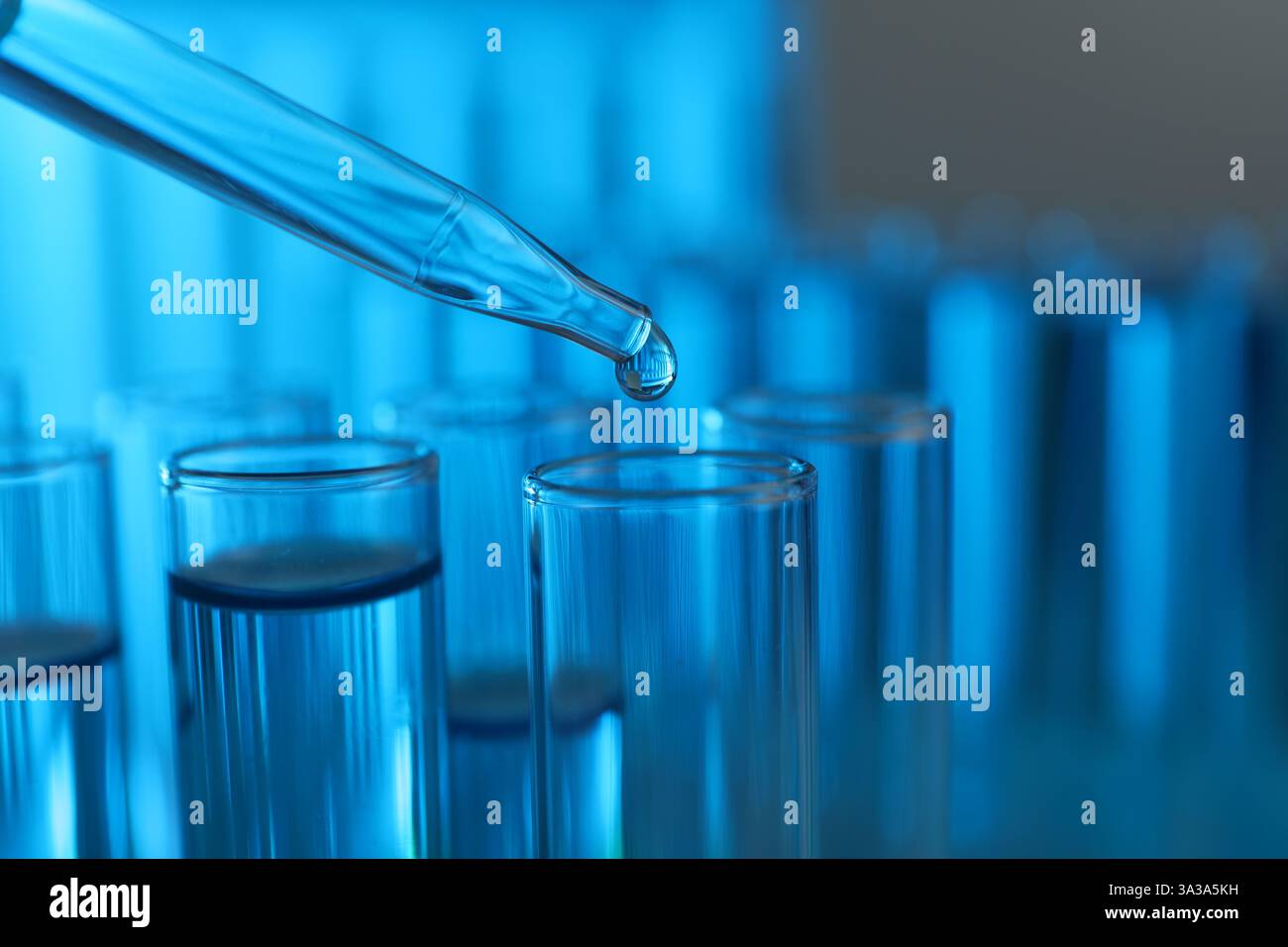 Dripping liquid into test tubes on blurred background, closeup Stock ...