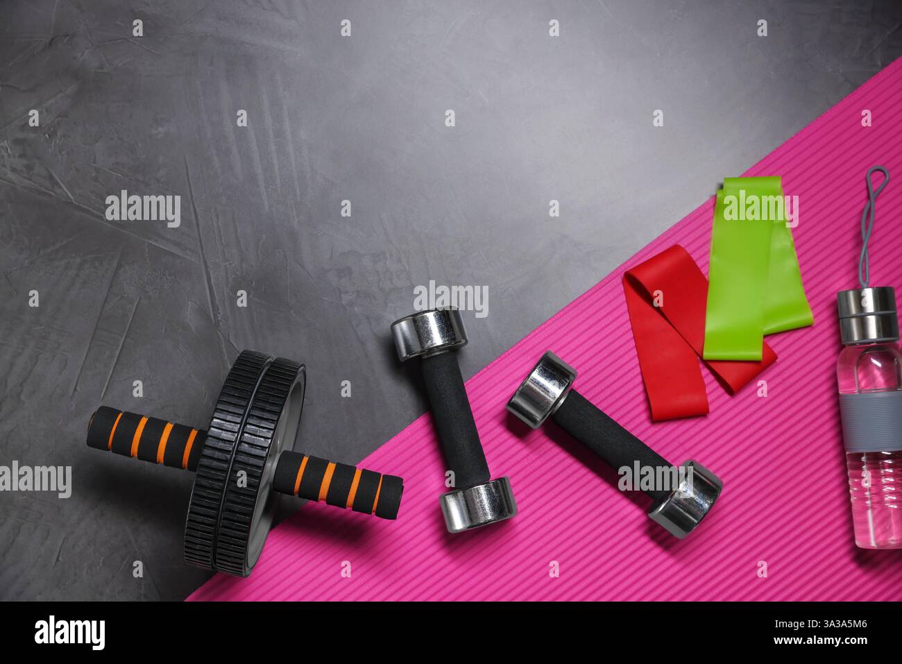 Different gym stuff on dark grey textured background, flat lay. Space ...