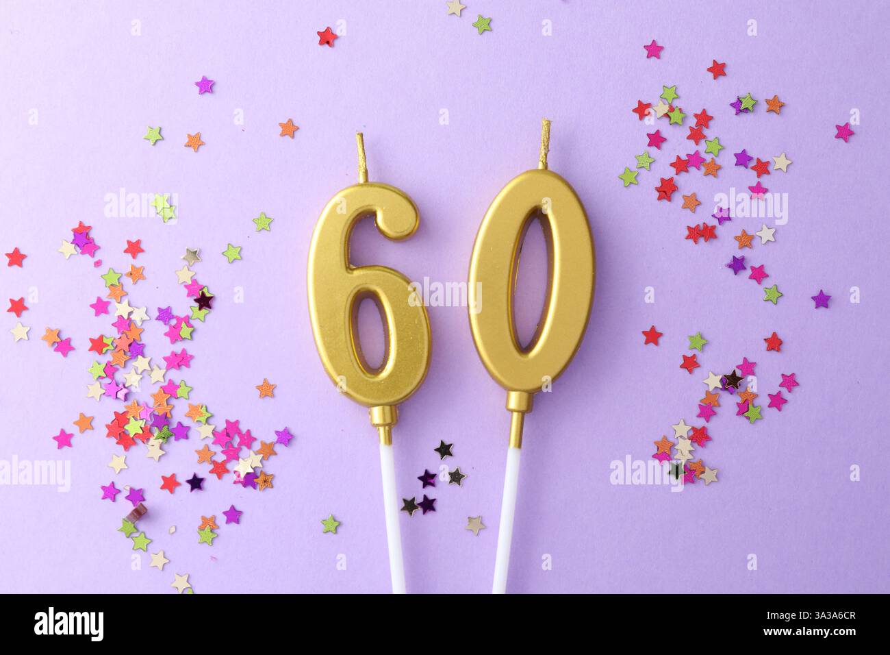60th birthday. Number shaped candles and confetti on violet background ...