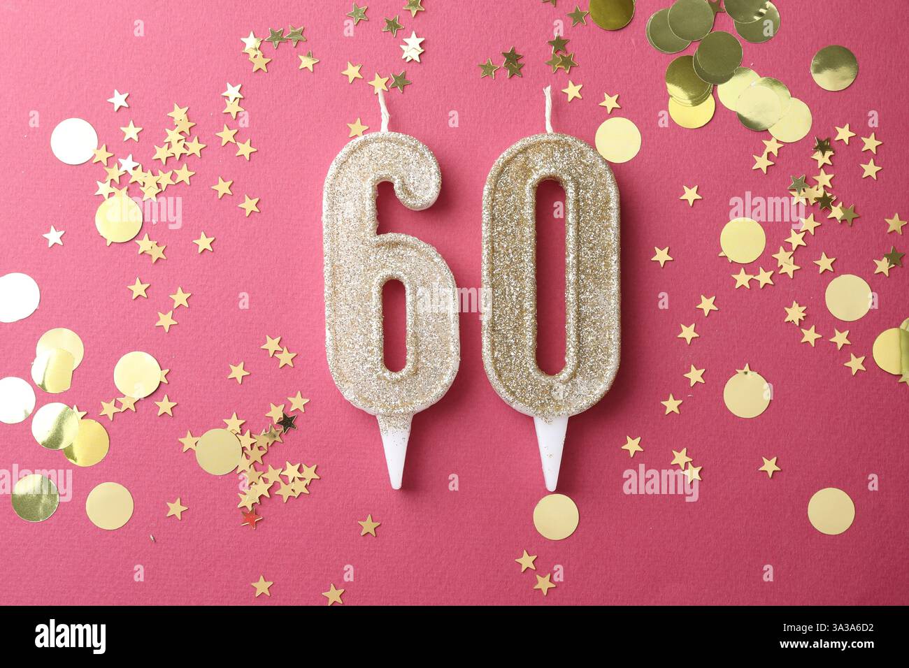 60th birthday. Number shaped candles and confetti on pink background ...