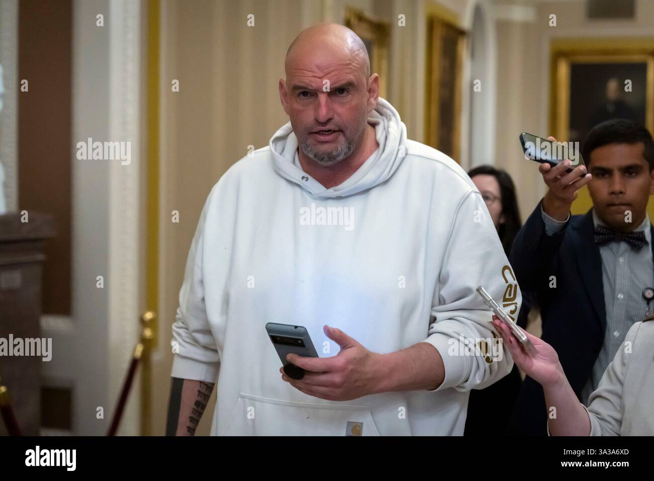Sen. John Fetterman, D-Pa., speaks to reporters as he walks near the ...