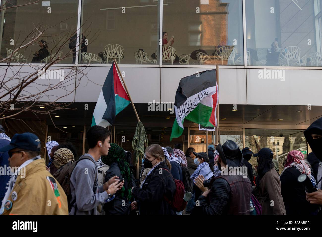 New York, United States. 14th Mar, 2025. Protesters march past students ...