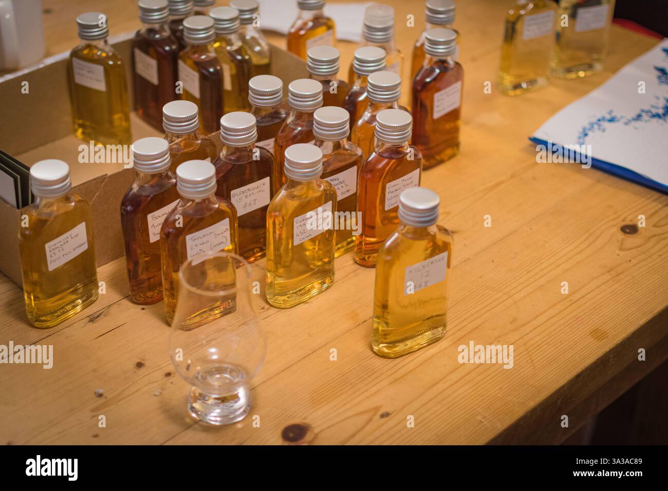 Multiple small Scotch whisky sample bottles, organized on a wooden ...