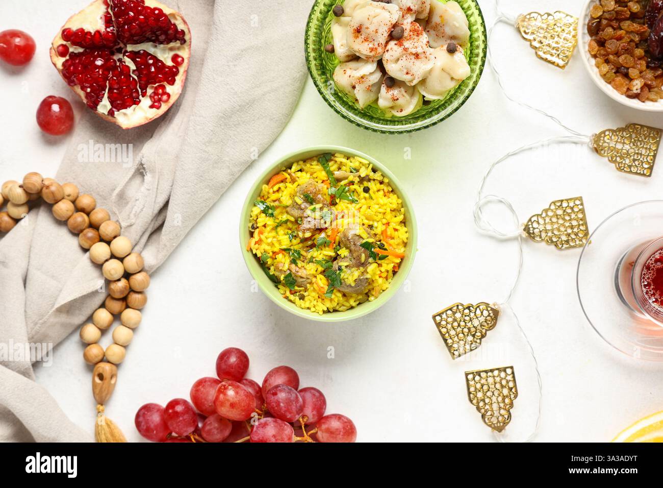 Traditional Eastern dishes, prayer beads and Muslim decor on white ...