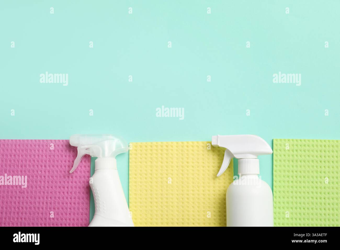 Bottles of detergent with rags on turquoise background Stock Photo - Alamy