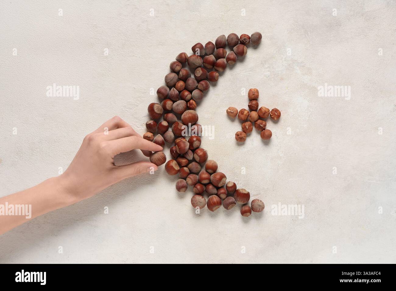 Hand with crescent and star made of hazelnuts as symbol of Islam on ...