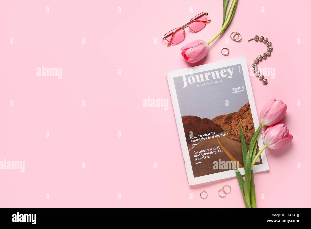Fashion magazine with flowers, sunglasses and jewellery on pink ...