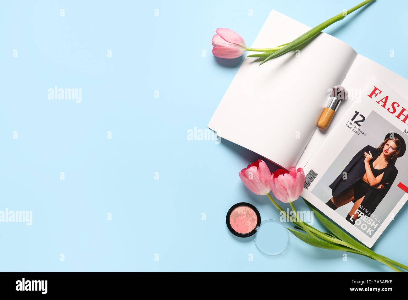 Blank fashion magazine with flowers and cosmetics on blue background ...
