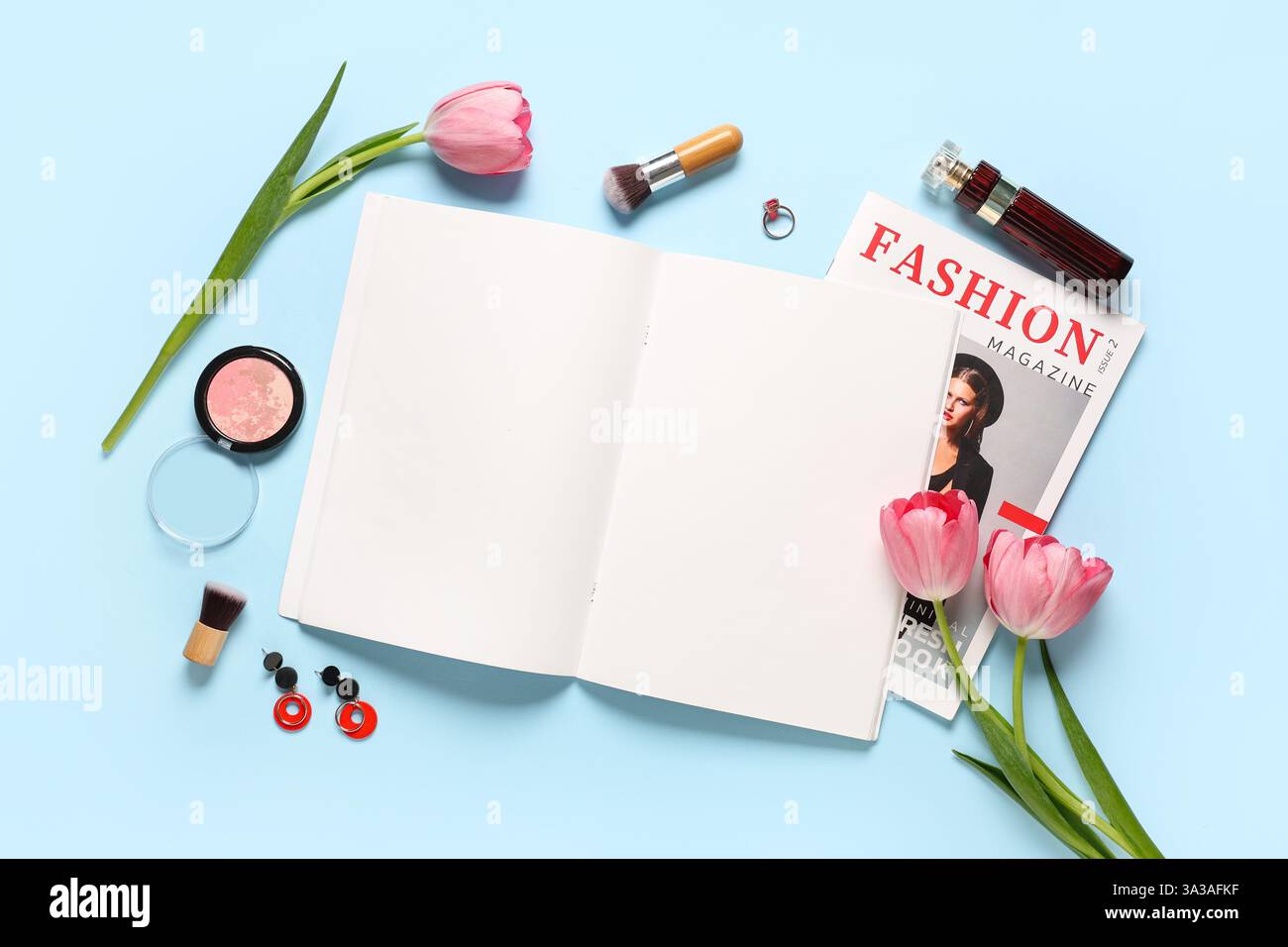 Blank fashion magazine with flowers, cosmetics and jewellery on blue ...