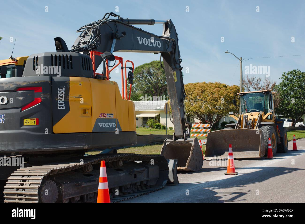 Excavator backhoe along with other construction vehicles, traffic cones ...