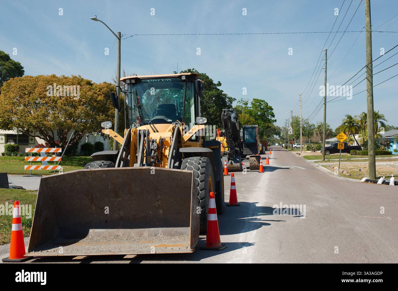 Excavator backhoe along with other construction vehicles, traffic cones ...